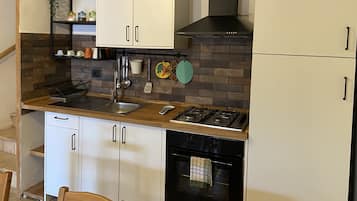 Apartamento, 1 quarto, vista para o jardim | Cozinha privada | Fogão, talheres/pratos/utensílios de cozinha