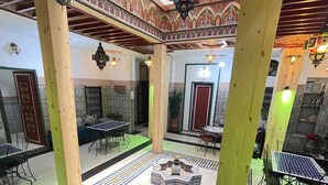 Um interior tradicional com piso estampado, pilares de madeira e lanternas penduradas.