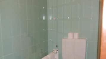 Um banheiro pequeno com vaso sanitário, porta-toalhas e suporte para papel higiênico.