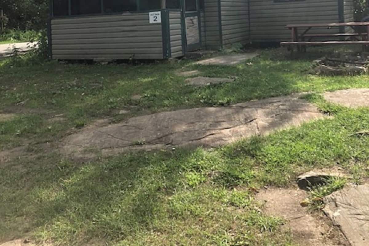 Uma casa pequena, térrea, com varanda coberta.