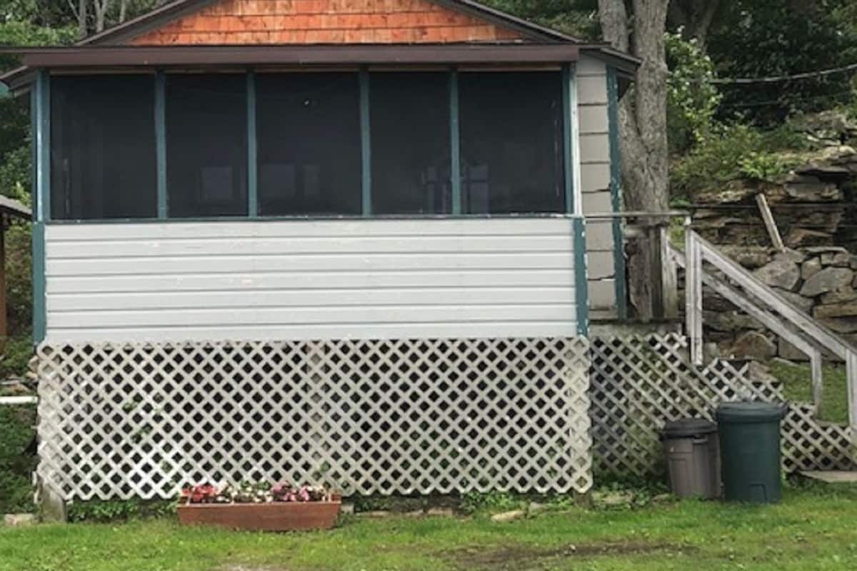 Um pequeno edifício térreo com telhado inclinado e fachada branca.