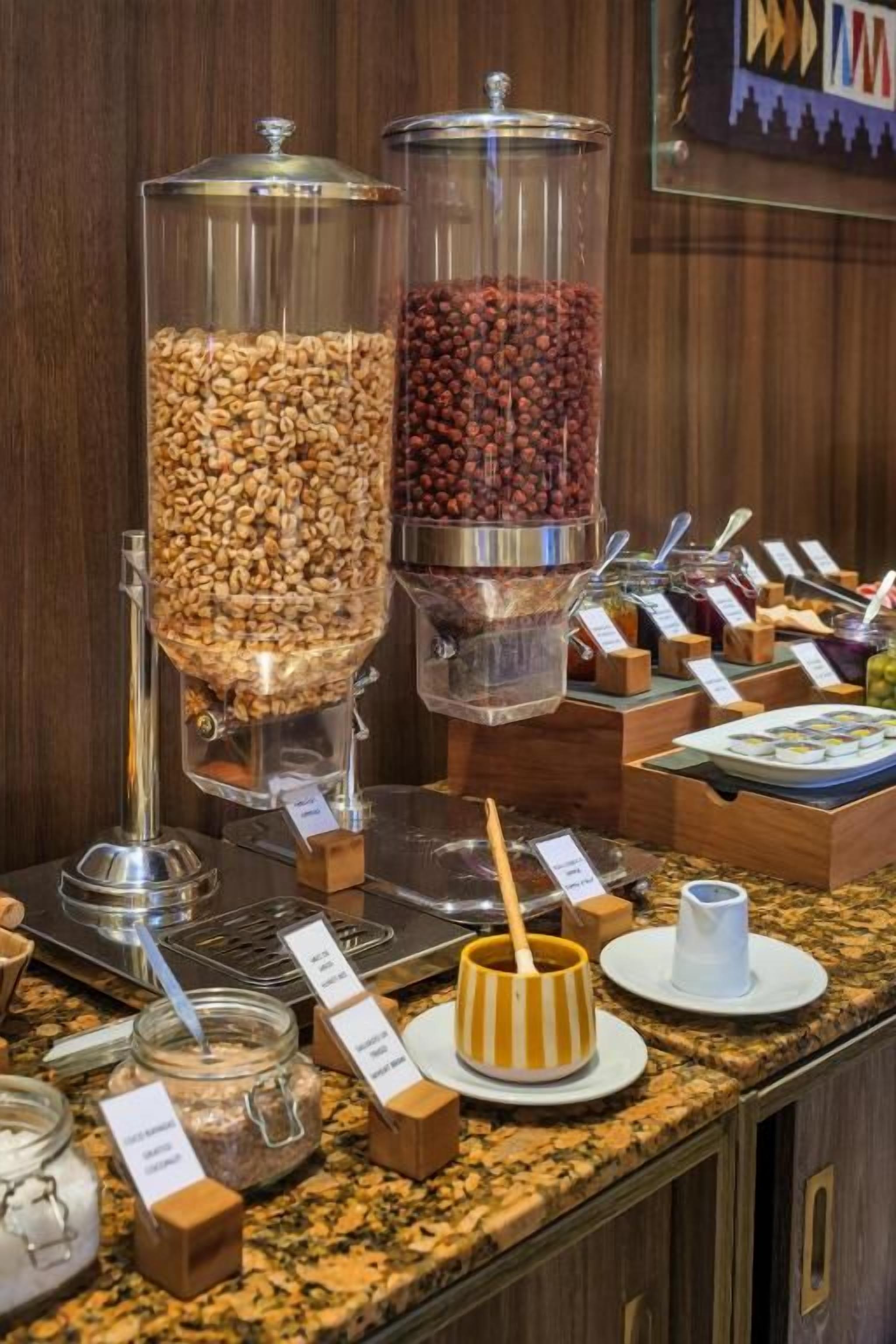 Uma área de buffet com distribuidores de alimentos e recipientes etiquetados.