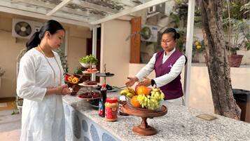 Disposição de buffet com diversos alimentos e uma pessoa servindo.