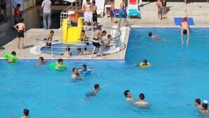 Piscina com várias pistas, plataforma de mergulho e tobogã.