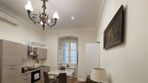 Uma cozinha compacta com área de refeições, um lustre e um quadro na parede.