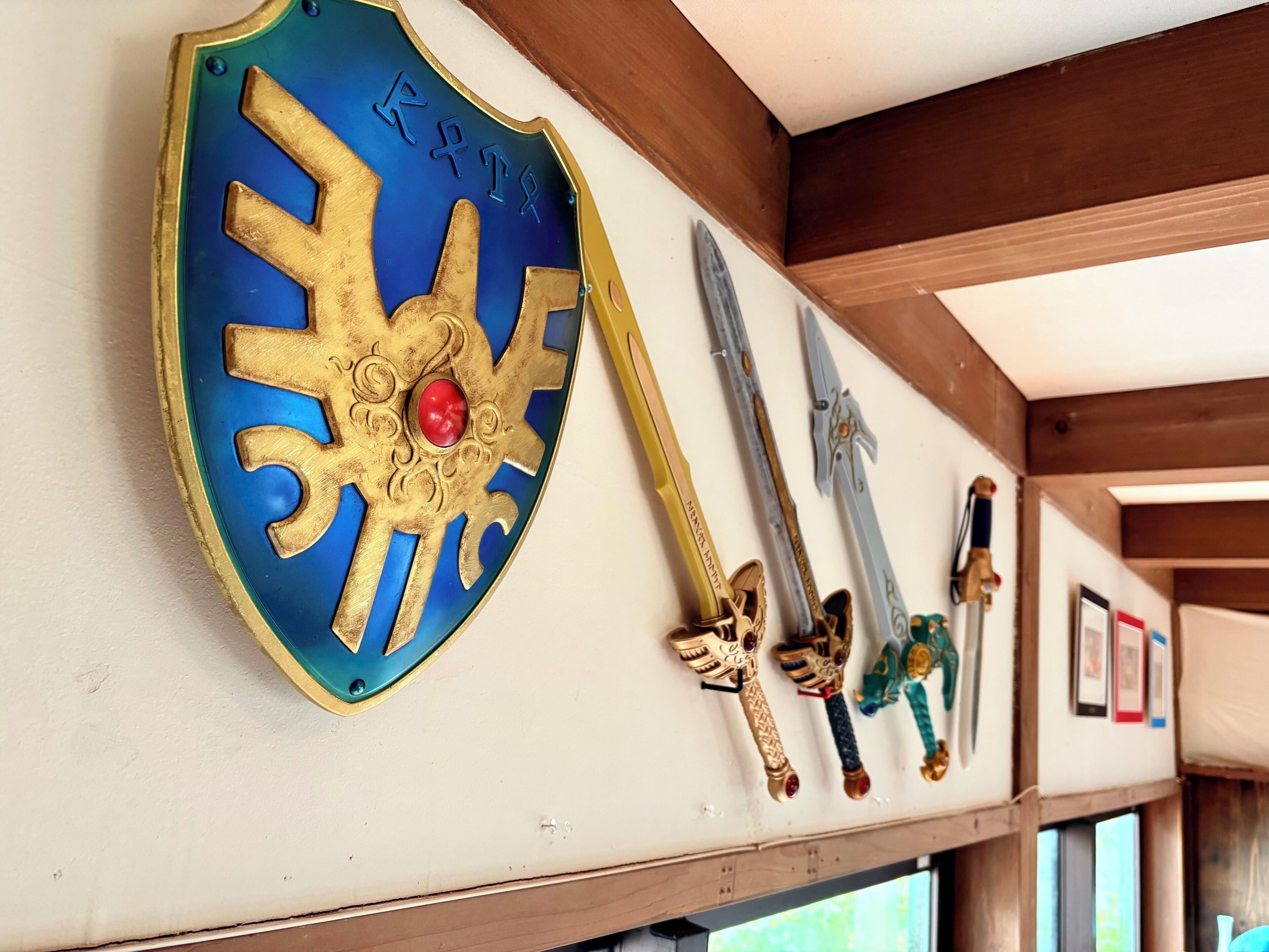 Paredes com um brasão em forma de escudo e várias espadas.