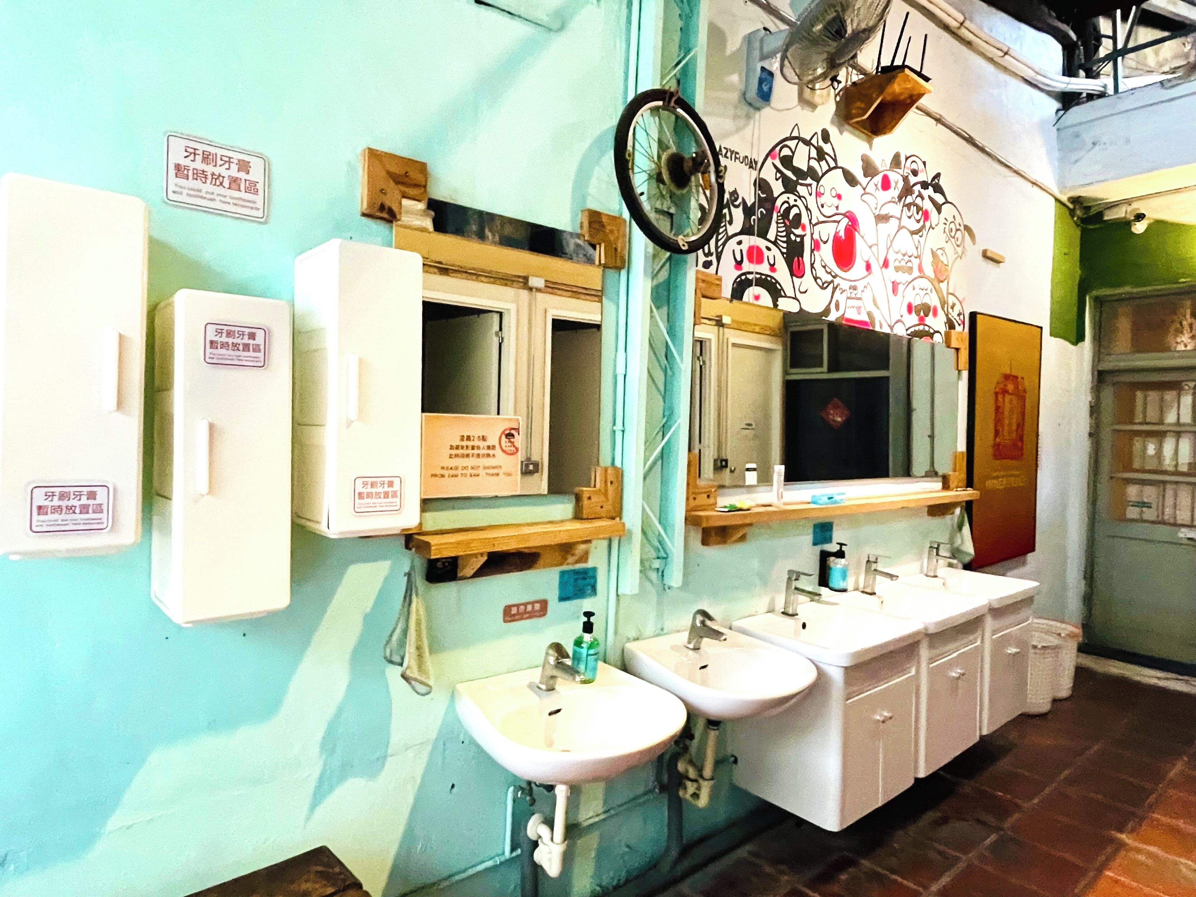 Casa de banho com duas pias, um espelho e um relógio na parede.