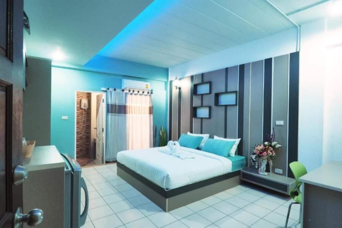 Quarto moderno com cama, escrivaninha e cadeira.