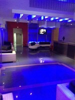 Uma área interna de piscina moderna, com espaço para sentar e uma tela de televisão.