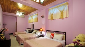 Quarto de hotel com duas camas, teto de madeira e uma pequena mesa com abajur.