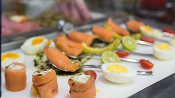 Diversos alimentos, incluindo salmão, ovos e vegetais em uma bandeja.