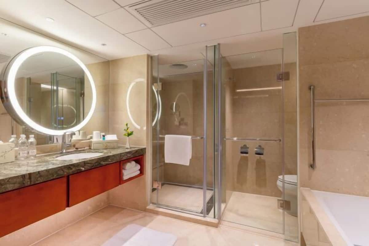 Um polibã e uma banheira separados, um chuveiro fixo