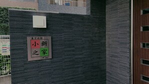 Um letreiro de hotel com caracteres japoneses e a palavra 'Hotel' abaixo.
