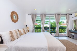 Um quarto espaçoso com uma cama grande, varanda com vista e banheiro moderno.