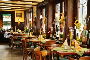 Um restaurante com mesas e cadeiras de madeira, velas e objetos decorativos.