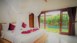 Quarto com cama, cortinas brancas e vista para um jardim.