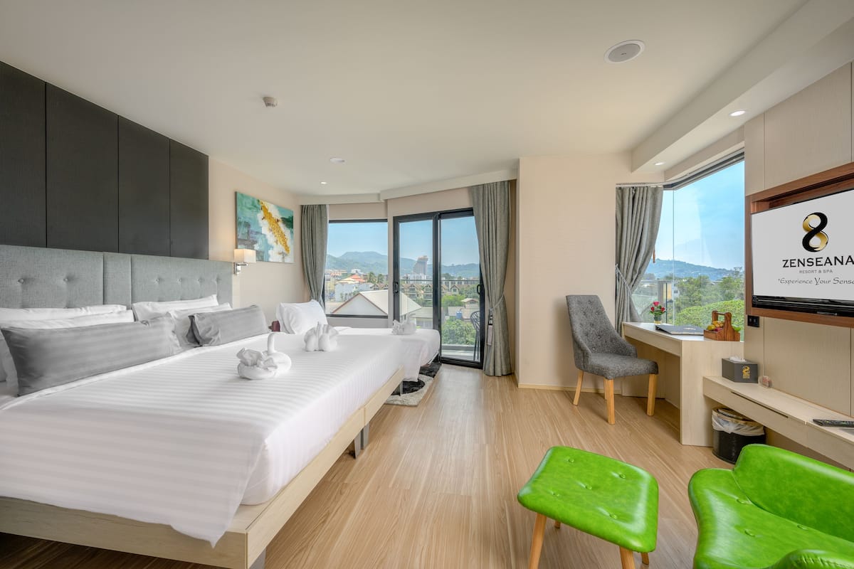 Quarto de hotel moderno com uma cama grande, uma mesa, uma cadeira e uma televisão.