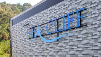 Um edifício com fachada de pedra e o nome "SEA CLIFF" em letras azuis.
