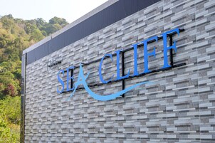 Um edifício com fachada de pedra e o nome "SEA CLIFF" em letras azuis.