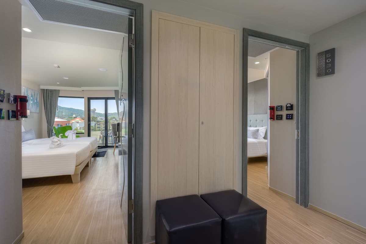 Quarto de hotel moderno com uma cama, área de estar e um guarda-roupa.