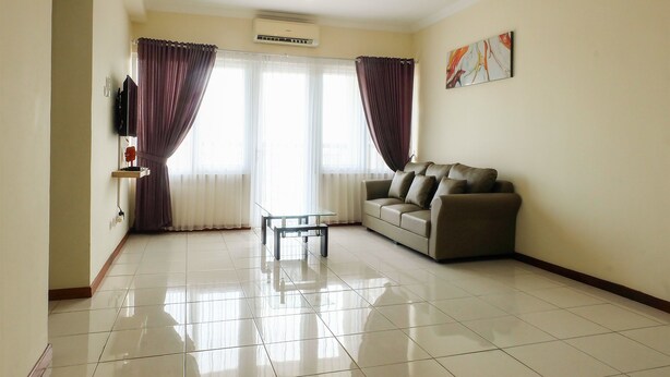 Uma sala de estar com sofá, mesa de centro e televisão.