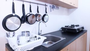 Cozinha com fogão, pia e panelas penduradas.