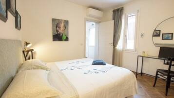 Quarto com cama, escrivaninha e cadeira.