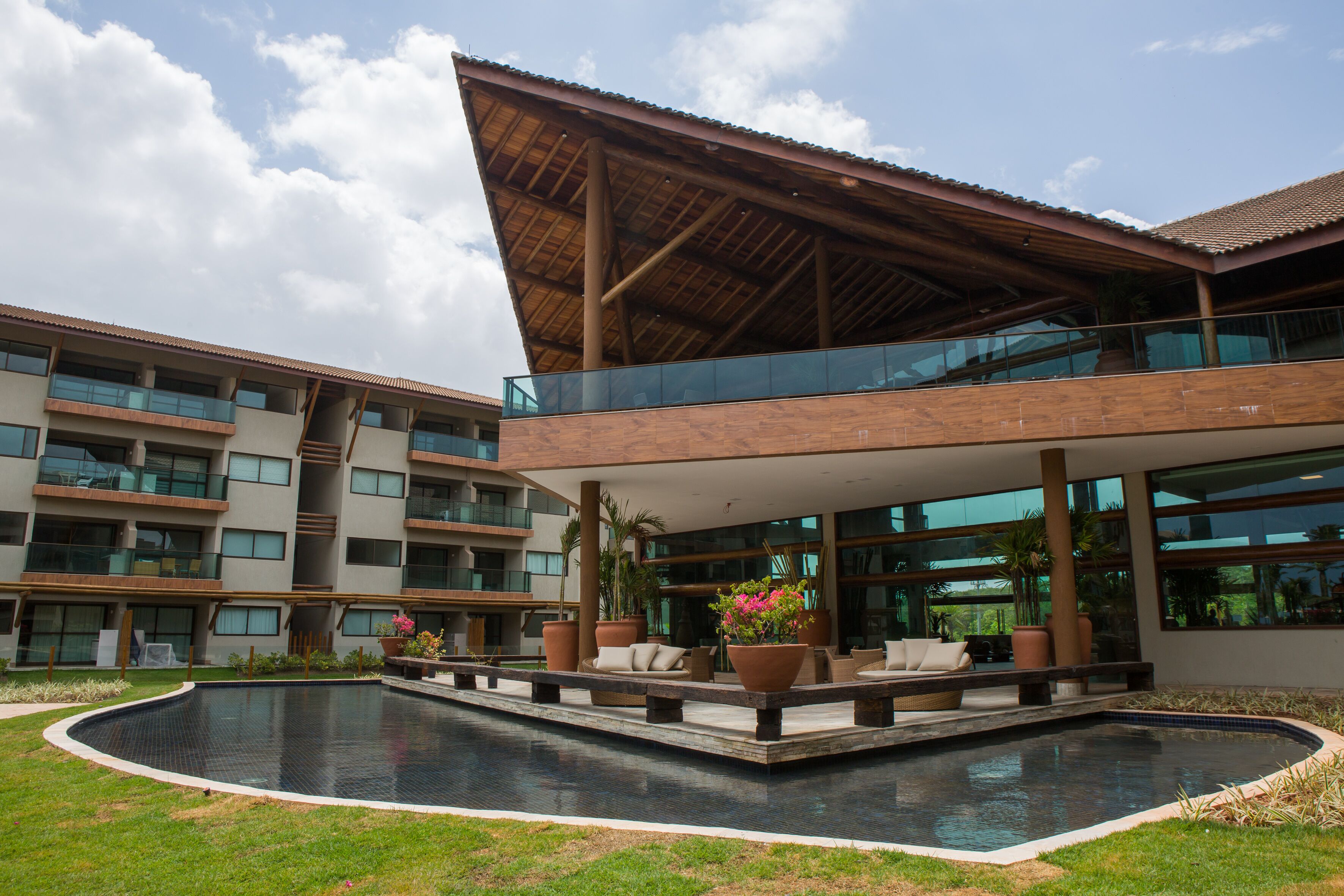 Um hotel moderno com piscina, área de estar externa e um pátio coberto.