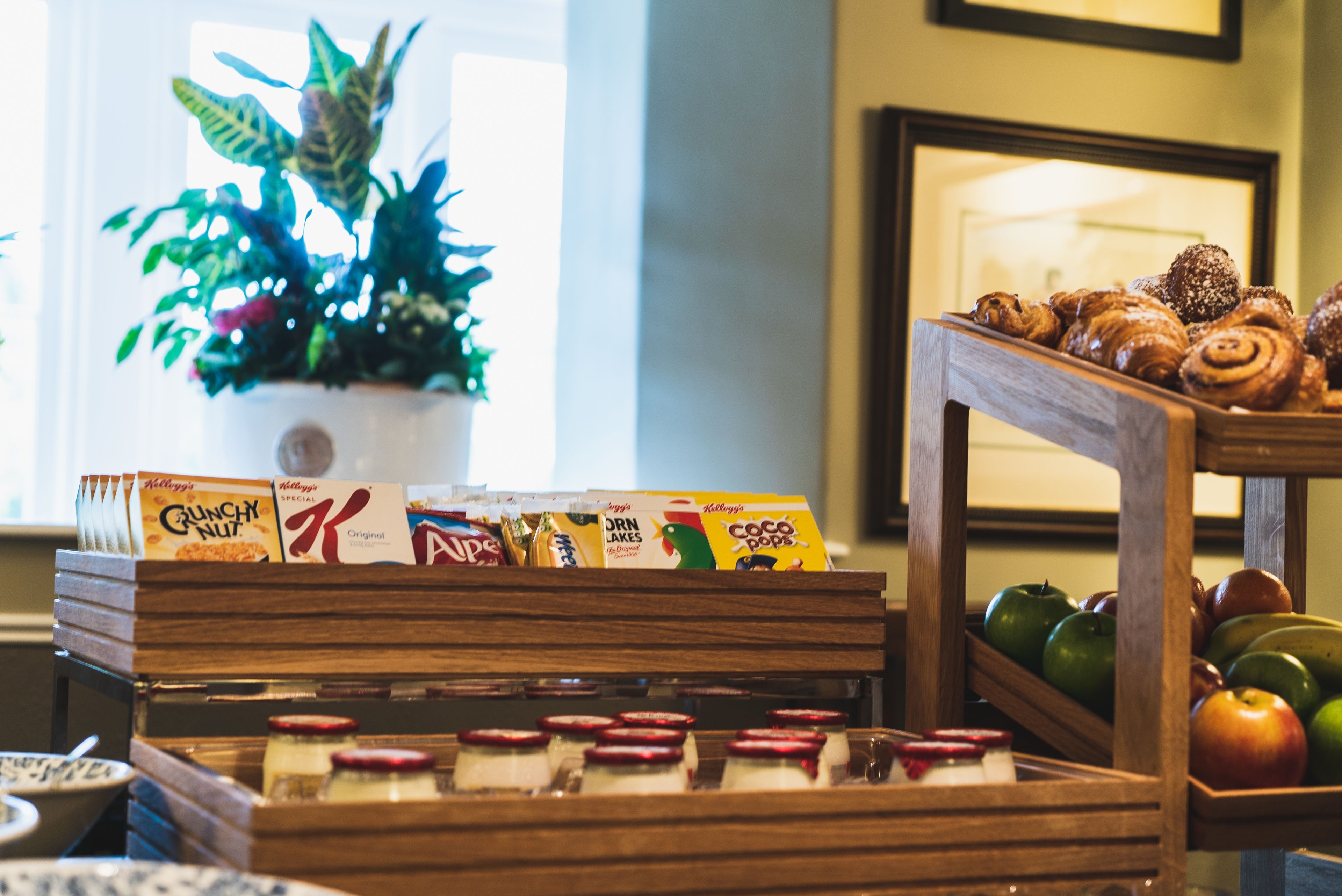 Um buffet de café da manhã com caixas de cereais, potes de geleia e uma variedade de doces.
