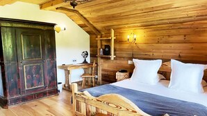 Quarto de madeira com uma cama, uma escrivaninha e uma cadeira.
