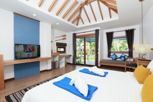 Quarto de hotel moderno com uma cama grande, televisão, escrivaninha e varanda com vista para palmeiras.