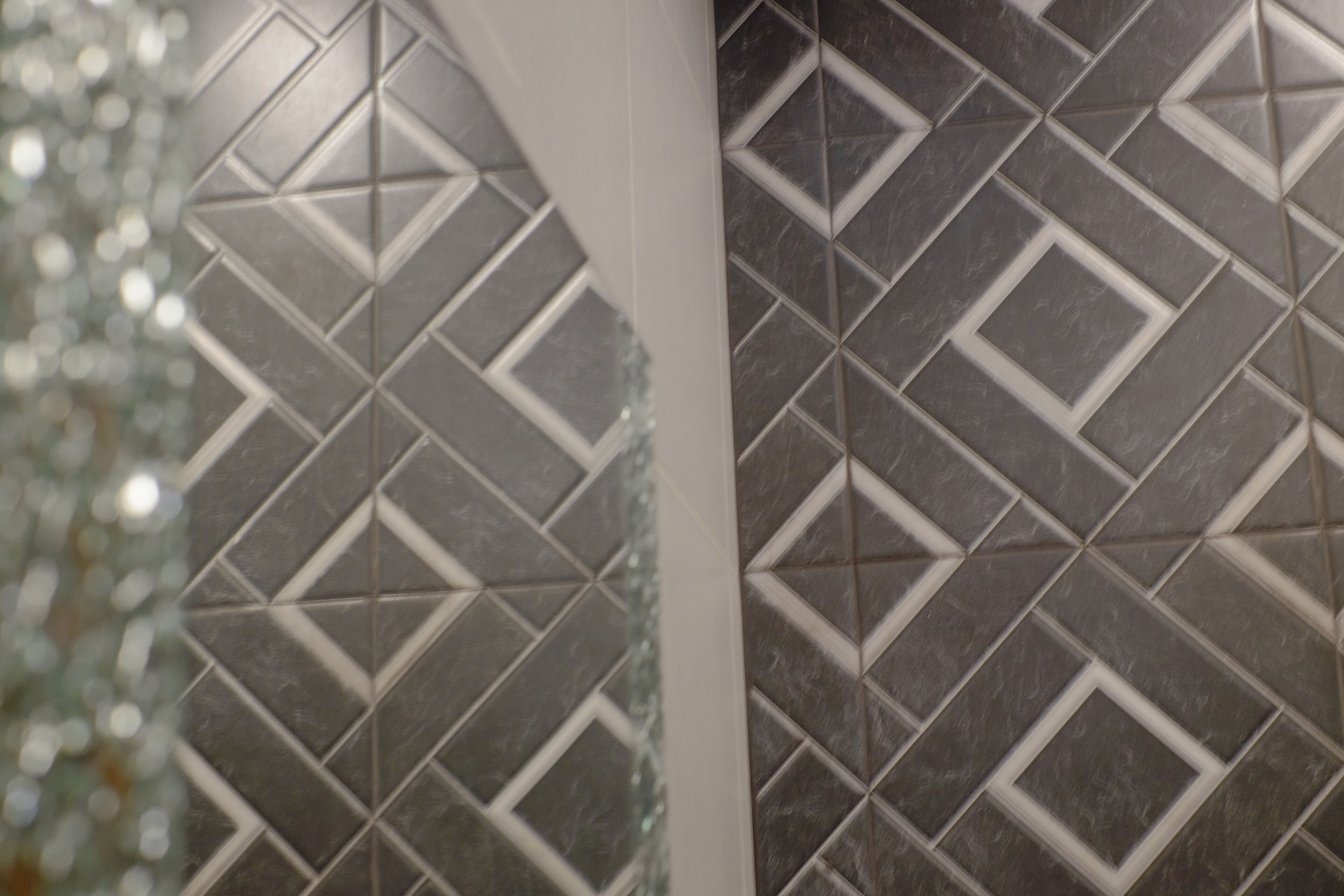 Um close-up de uma parede com um padrão geométrico de azulejos.