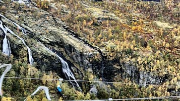 Paisagem montanhosa com estrada sinuosa e sistema de teleférico.