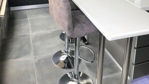 Uma cozinha moderna com frigorífico embutido, máquina de café e micro-ondas Hitachi.
