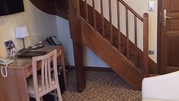 Quarto com escada de madeira, escrivaninha com cadeira, cama e porta.