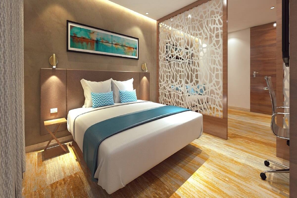Quarto moderno com uma cama grande, um painel decorativo e um quadro acima da cama.