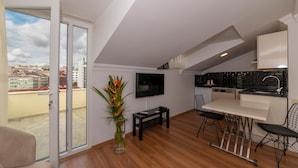 Um apartamento moderno com varanda, área de jantar e cozinha.