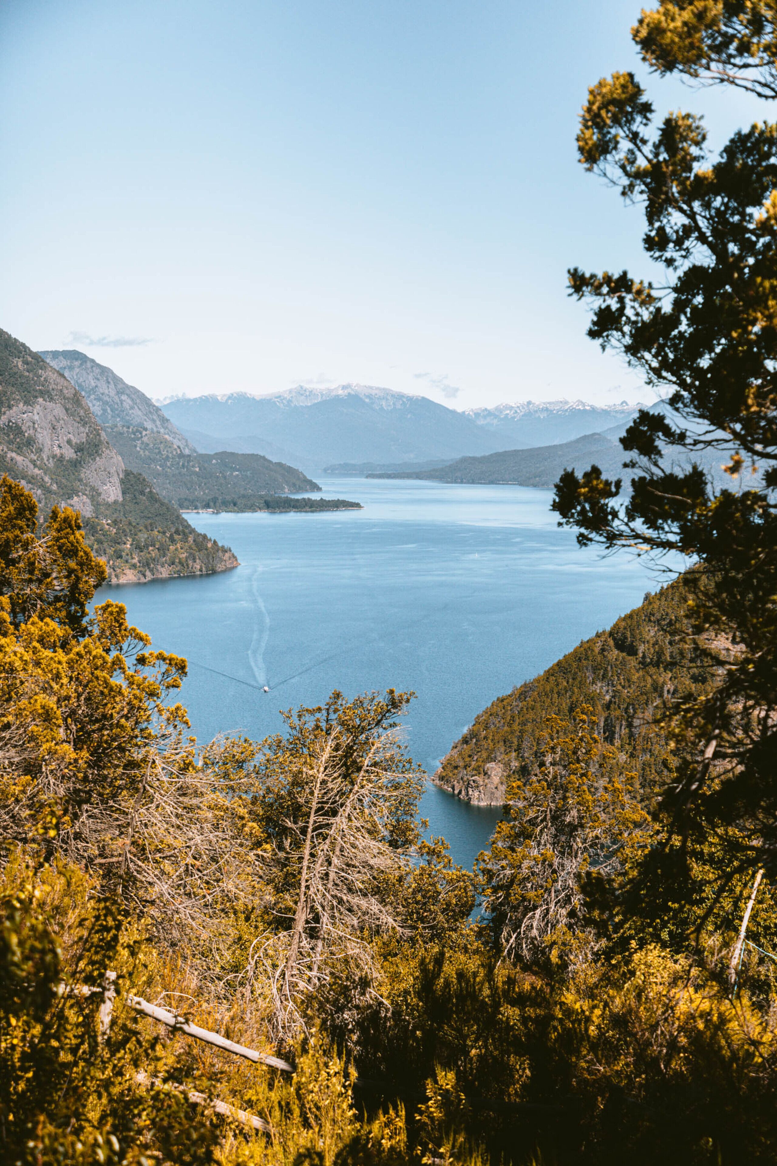 Paisagem montanhosa com um lago e floresta densa.
