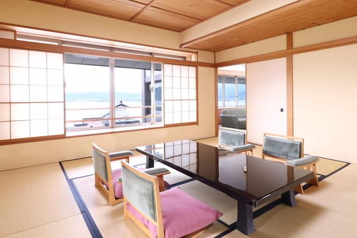 Um quarto japonês tradicional com tatames, uma mesa baixa e painéis shoji.