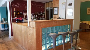 Uma área de bar com painéis de madeira, painel de azulejos e banquetas.