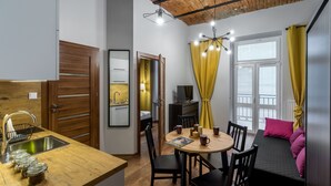 Espaço compacto com cozinha, área de refeições e canto de dormir com cama.