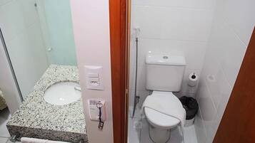 Casa de banho com lavatório de granito, sanita e zona de duche.