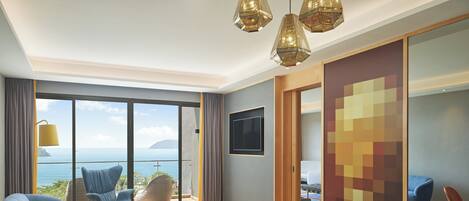 Quarto de hotel moderno com uma varanda ampla, uma mesa redonda de madeira e assentos confortáveis.