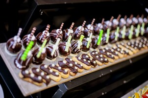Uma bandeja de doces cobertos de chocolate com palitos verde e branco.