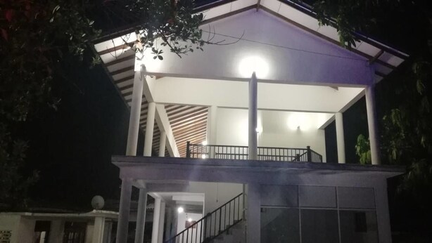 Um edifício de dois andares com uma varanda e escadaria que dá acesso ao andar superior.