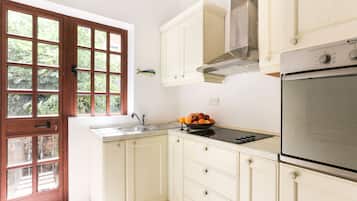Refrigerador em uma área comum, fogão, cooktop, chaleira elétrica