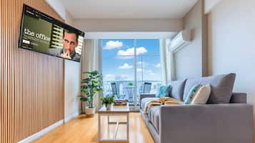 Apartamento luxo, 1 quarto | Área de estar | Smart TV 43 polegadas com canais a cabo, TV