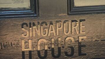 Uma porta de madeira com a inscrição 'SINGAPORE HOUSE'.