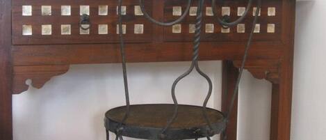 Uma cadeira de metal com encosto curvo e uma mesa de madeira com design em grade.