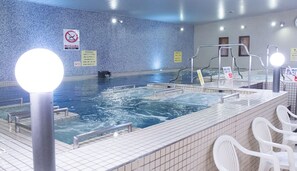Piscina com paredes revestidas, placa de proibição de mergulho e indicador de temperatura mostrando 34°C.